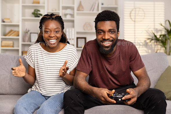 Couple Gaming Together on a Cozy Sofa at Home Stock Photo by puhhha