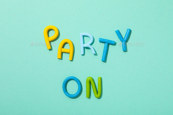 The word "party" is made of colored plasticine on a turquoise ...