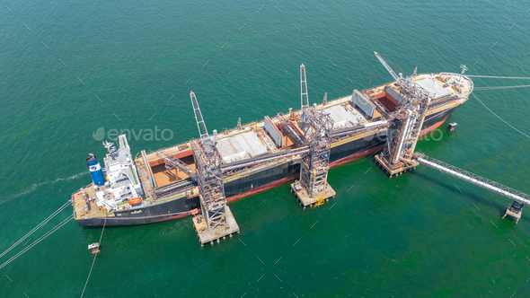Aerial top view wood chips load chip from silo to cargo ship vessel ...