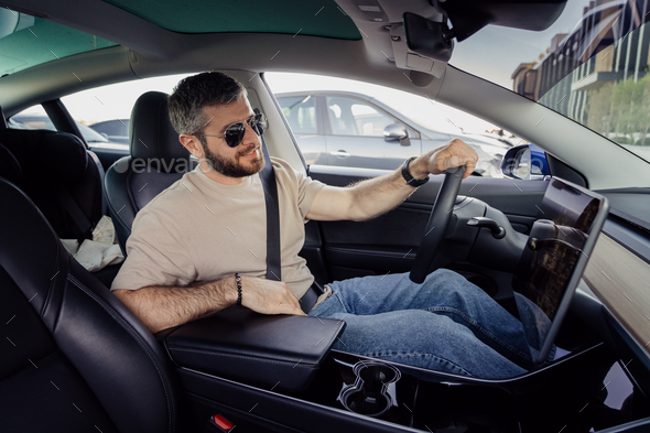 Man driving electric car with modern interior design Stock Photo by ...