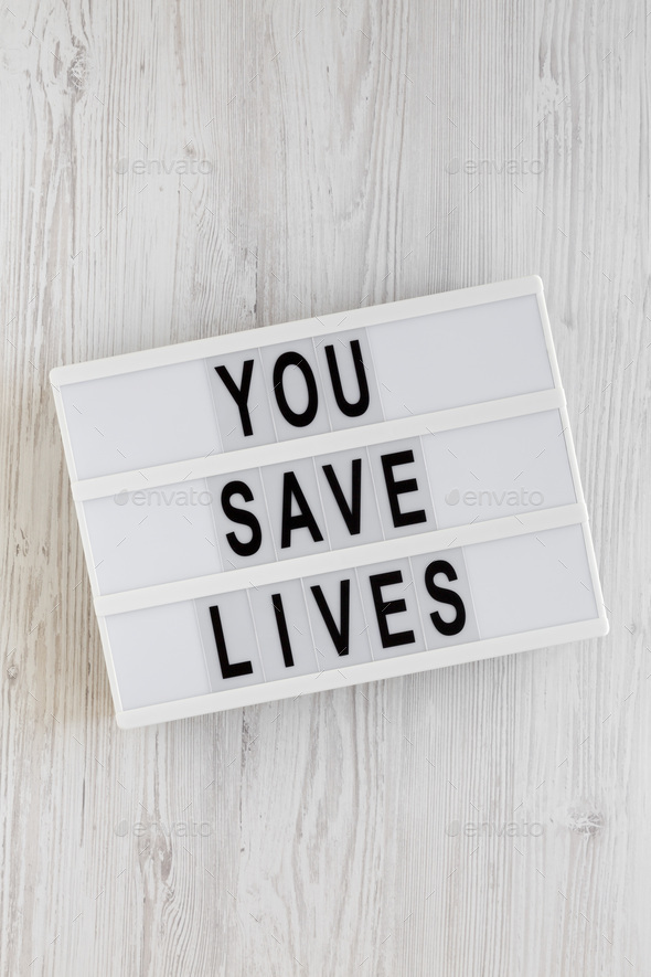 'You save lives' words on a lightbox on a white wooden surface, top ...