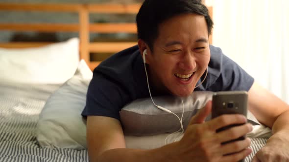 Asian Man Making Facetime Video Calling with Smartphone at Home Waving ...