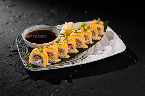 Elegant sushi rolls platter with dipping sauce Stock Photo by AntAlexStudio