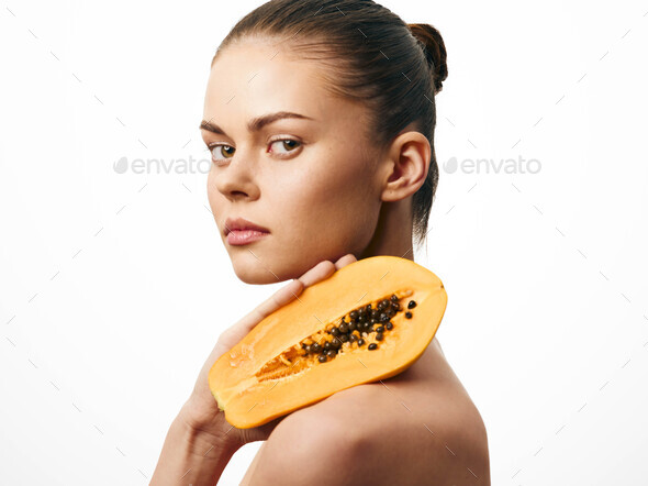Attractive young woman holding papaya fruit on her shoulder, isolated ...