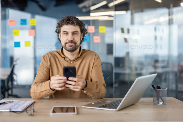 Professional man using smartphone at modern office desk Stock Photo by ...