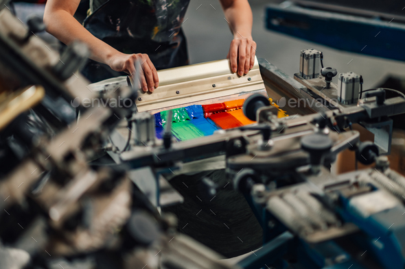 Close up of graphic worker's hands screen printing with squeegee. Stock ...