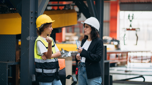 Industrial worker inspecting and check up machine at factory machines ...
