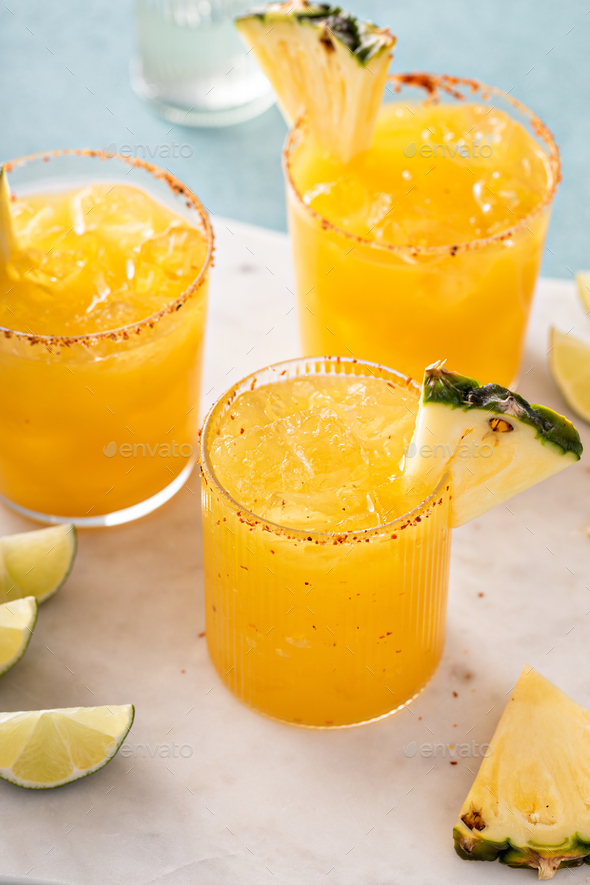 Pineapple margarita cocktail in glasses with tajin rim Stock Photo by ...