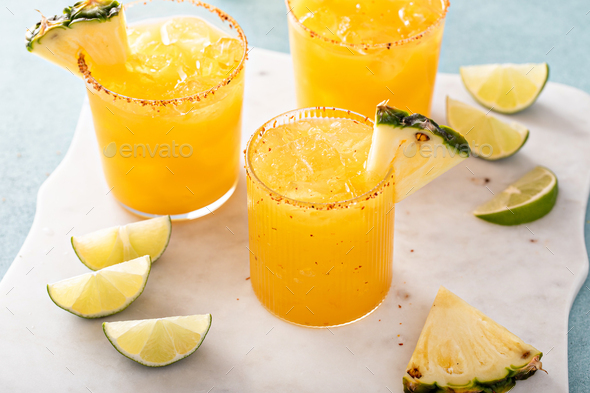 Pineapple margarita cocktail in glasses with tajin rim Stock Photo by ...