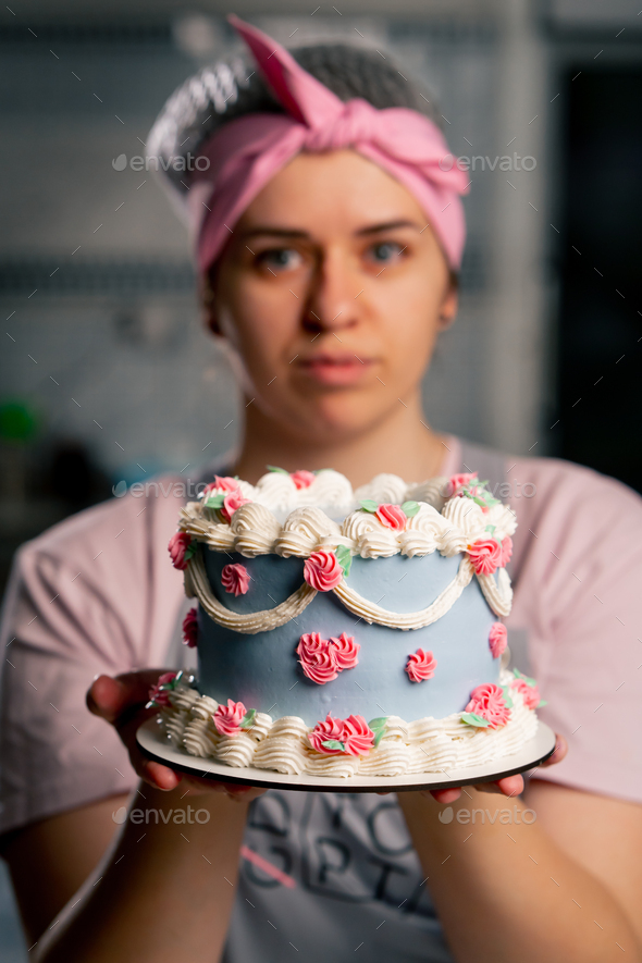 close-up in a professional kitchen a female baker stands with a ...