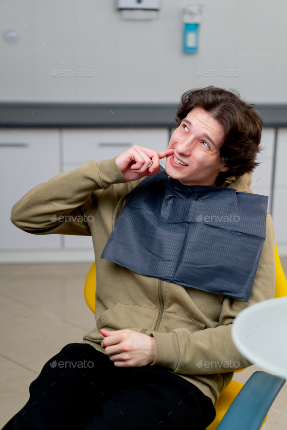 dental office blonde dentist consulting patient guy talking about bad ...