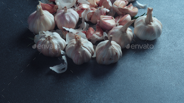 Whole and Split Garlic Bulbs on Dark Surface. Stock Photo by TaniaJoy