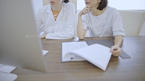Caucasian Medical staff reviewing paperwork together in office. Stock ...