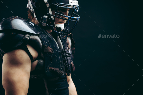 American football player with ball wearing helmet and protective ...