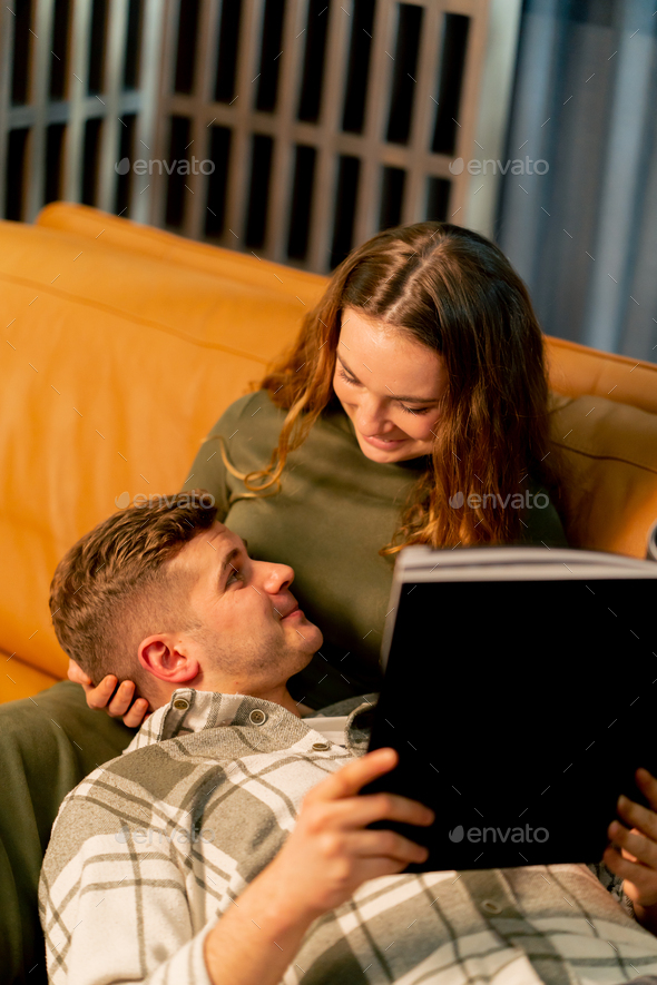 close up young couple in love on a yellow sofa hugging and flirting guy ...