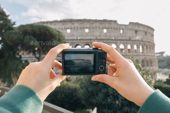 A girl takes pictures of the Roman Colosseum with her small digital ...