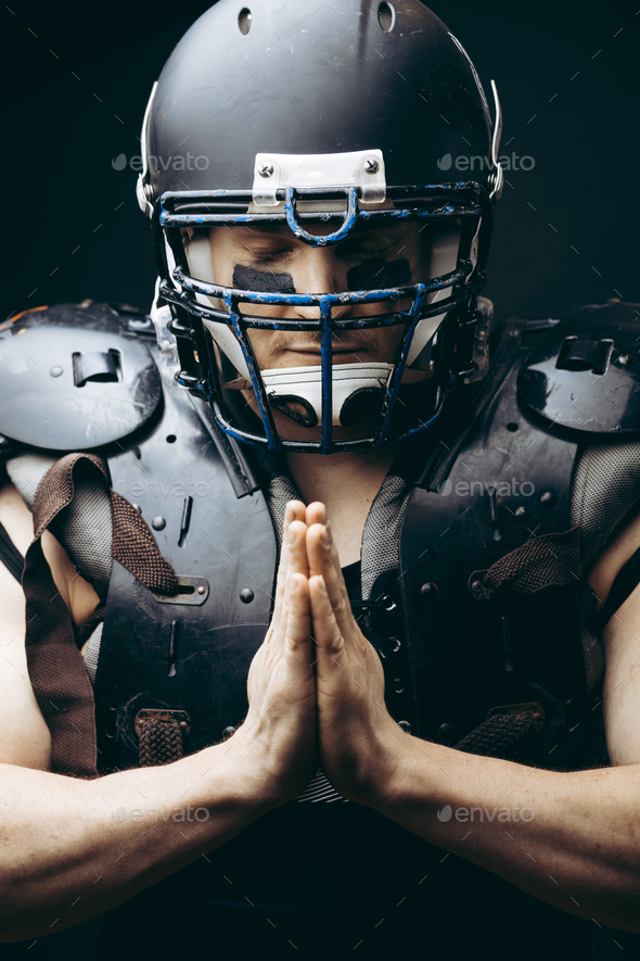 American football player with ball wearing helmet and protective ...