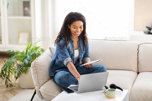 Millennial Black Woman Sitting on Couch Using Laptop Computer Stock ...