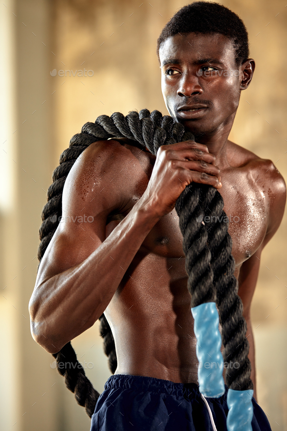Rope workout. Sport man doing battle ropes exercise outdoor. Black male ...