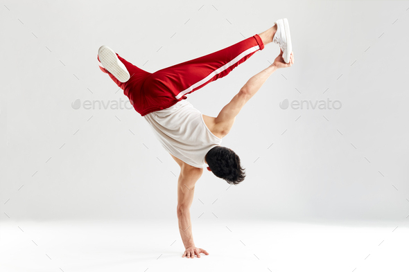 Modern dancer stands on one hand freeze with hands splitted out in air ...