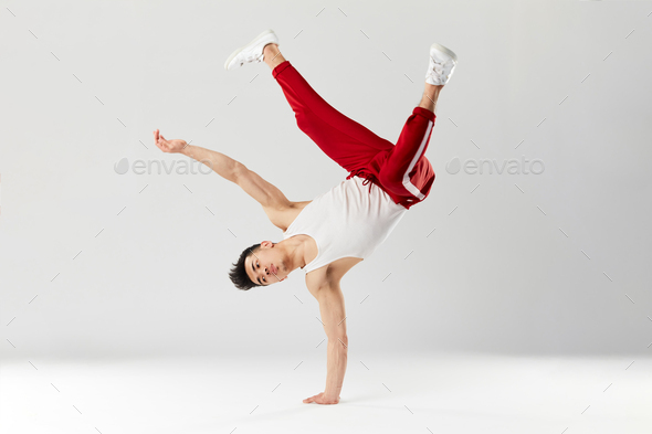 Modern hip-hop Asian dancer standing on one hand dancing isolated on ...