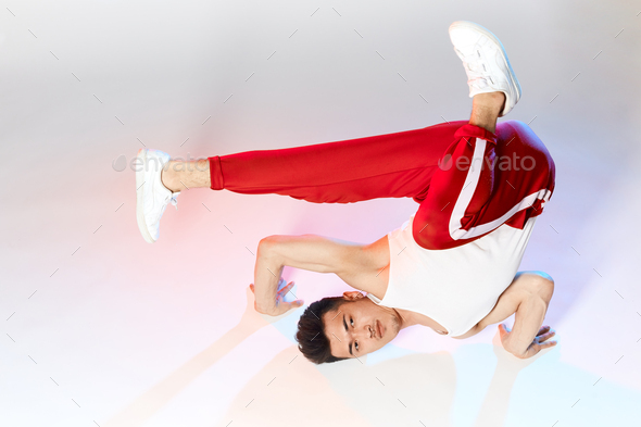 Asian male breakdancer dancing on white background, doing shoulder ...