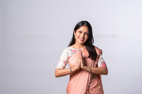 Indian pretty young woman posing with namaskara, namaste or welcome ...