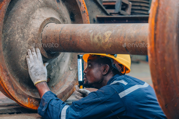 Rail technician inspects train wheels with flashlight for faults and ...