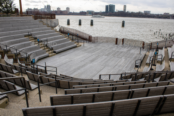 Outdoor concert seating by water with city skyline in the background ...