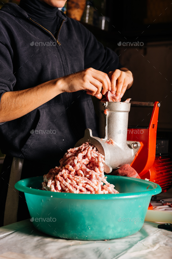 Crop of young lady hands grinding beef in kitchen using kitchen ...