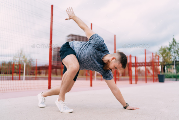 Concentrated male athlete training on sports ground Stock Photo by GaudiLab
