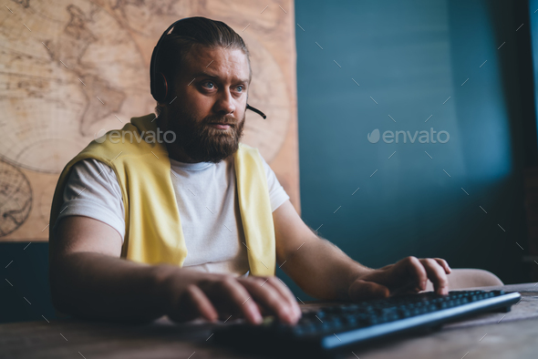 Concentrated male gamer typing on keyboard Stock Photo by GaudiLab