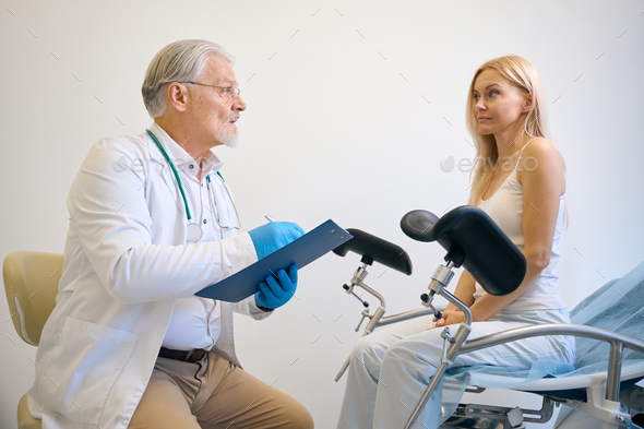 Doctor making notes before treatment in clinic Stock Photo by Iakobchuk