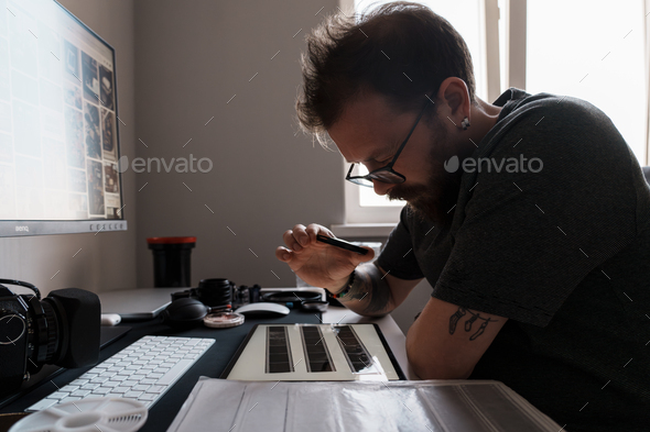 Photographer analyzing film negatives on a lightbox Stock Photo by ...