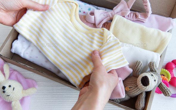 Women's hands collect children's clothes into boxes. Stock Photo by ...