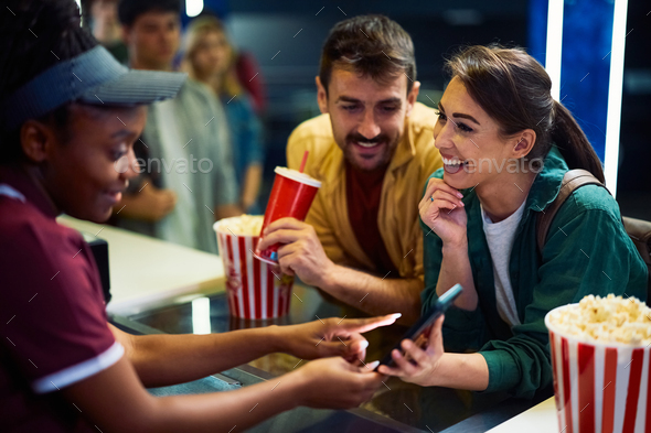 Happy couple choosing seats on online mobile app while talking to ...