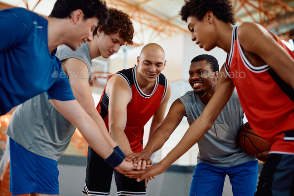 Happy basketball players holding hands in unity on the court. Stock ...