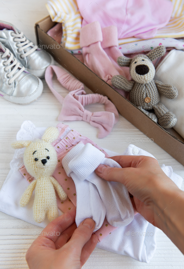 Women's hands collect children's clothes into boxes. Stock Photo by ...