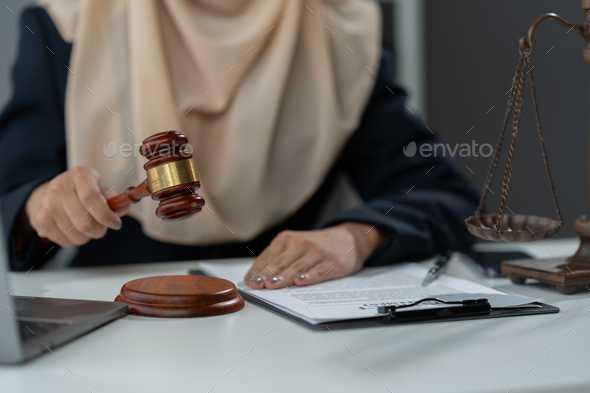female Muslim lawyer wearing hijab holding the hammer of justice ...
