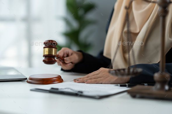 female Muslim lawyer wearing hijab holding the hammer of justice ...