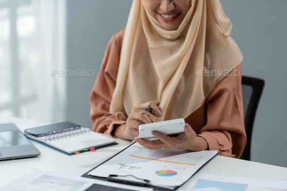 Motivated muslim businesswoman wearing hijab working on real estate ...