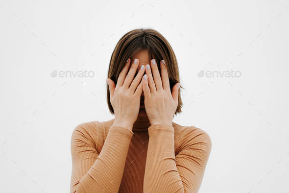 Portrait of upset scared adult Caucasian woman covering face with hands ...