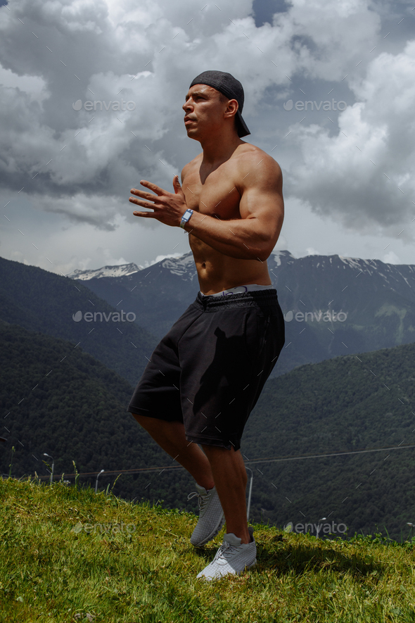 Bodybuilder posing in mountains. Handsome strong man showing his ...