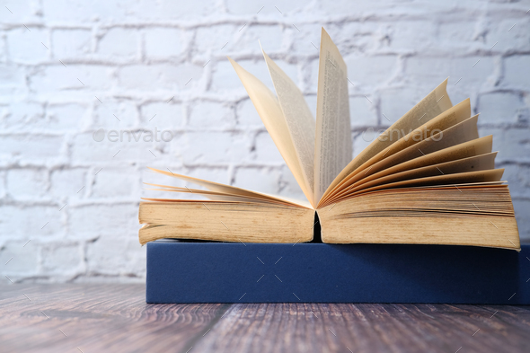 open book on table against a wall. Stock Photo by towfiqu98 | PhotoDune