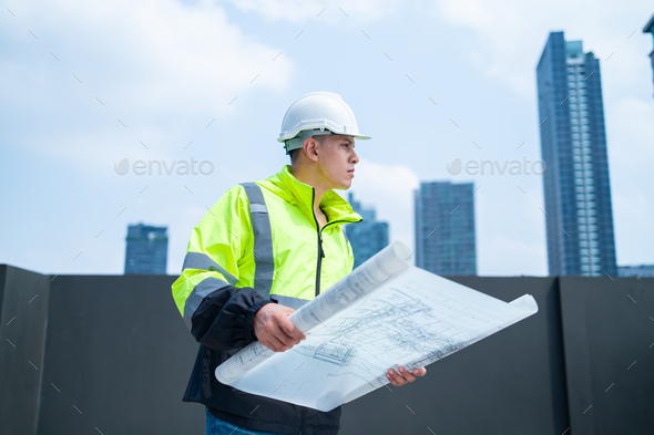 Construction Engineer Evaluating Blueprints on Rooftop Stock Photo by ...