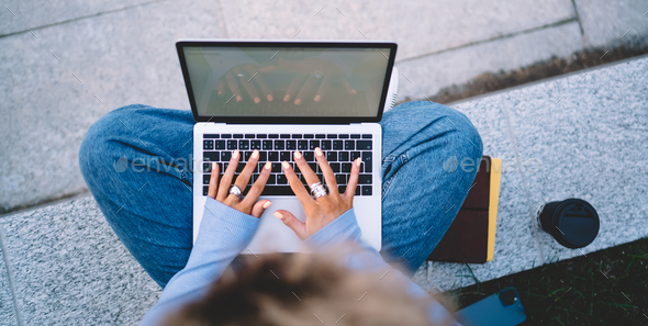 Faceless woman sitting with laptop on knees and typing text Stock Photo ...