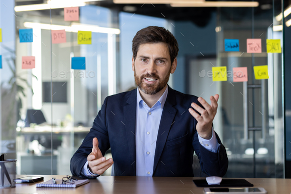 Professional man talking during a video call in an office setting Stock ...