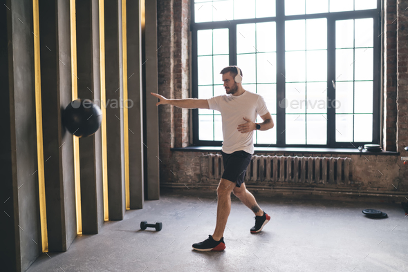 Man throwing medicine ball in modern gym Stock Photo by GaudiLab ...