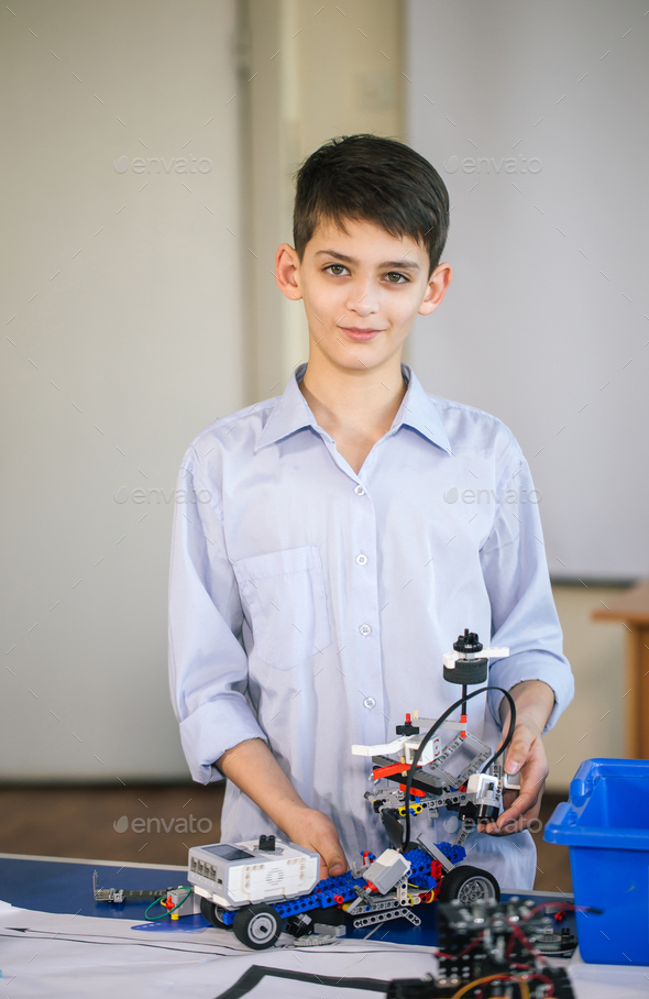 Little boy in robotics school makes robot Stock Photo by Albertshakirov