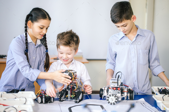 Kids playing with electrical robot while visiting robotics exhibition ...